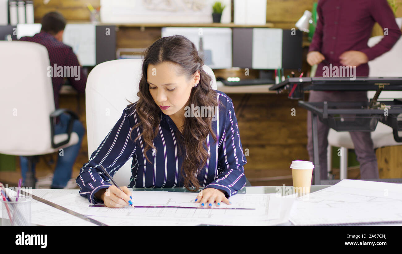 Busy creative designer working on blueprints in professional ...