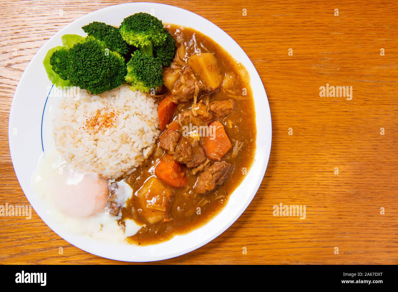 Pork Curry Rice on wooden background ( Onsen tamago, Potato, enoki ...