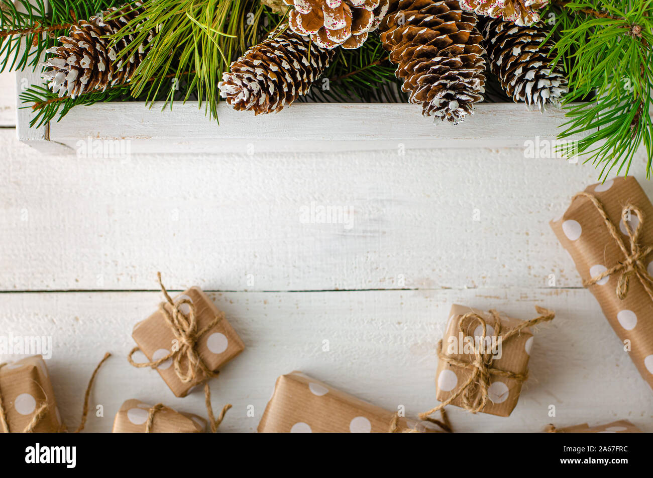 Greeting card composition with pine cones, gift boxes and fir on white ...
