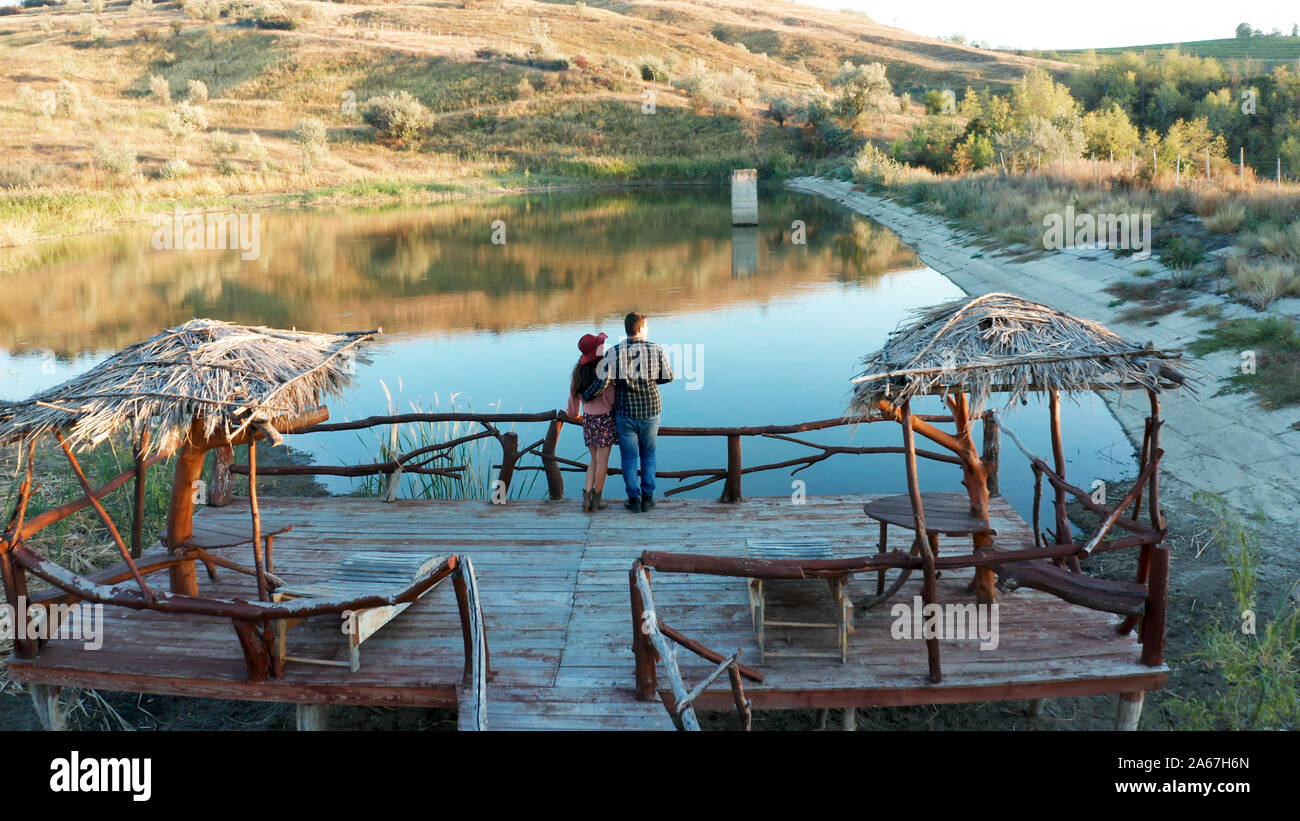 Couple on a pontoon bridge in a vacation in rural area with a lake ...