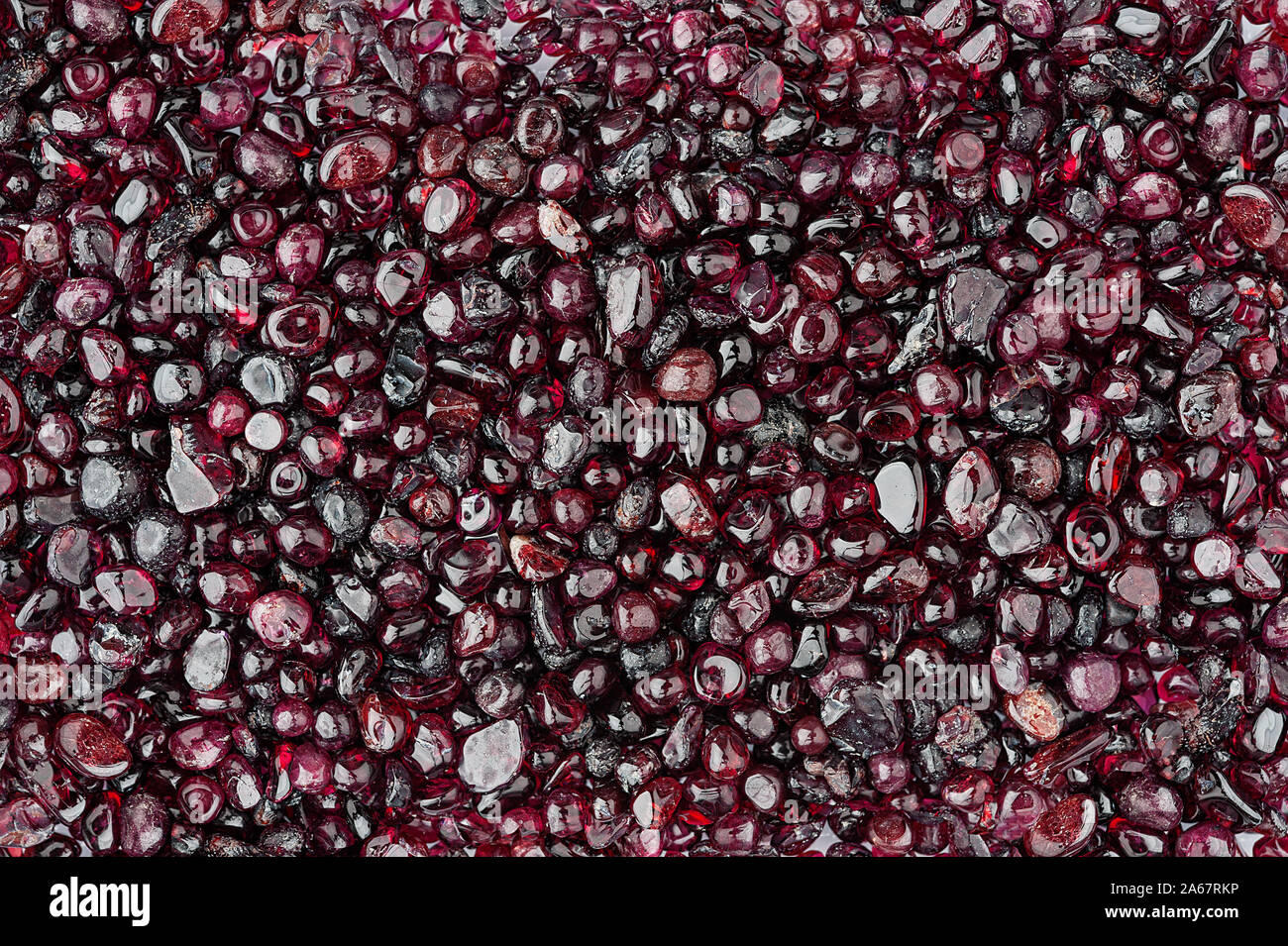 Small rounded garnet stones textured background Stock Photo - Alamy
