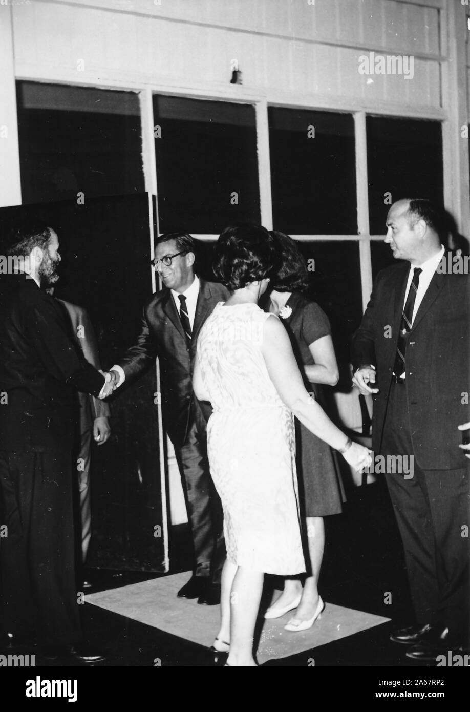 Full-length shot of formally dressed men and women greeting each other ...