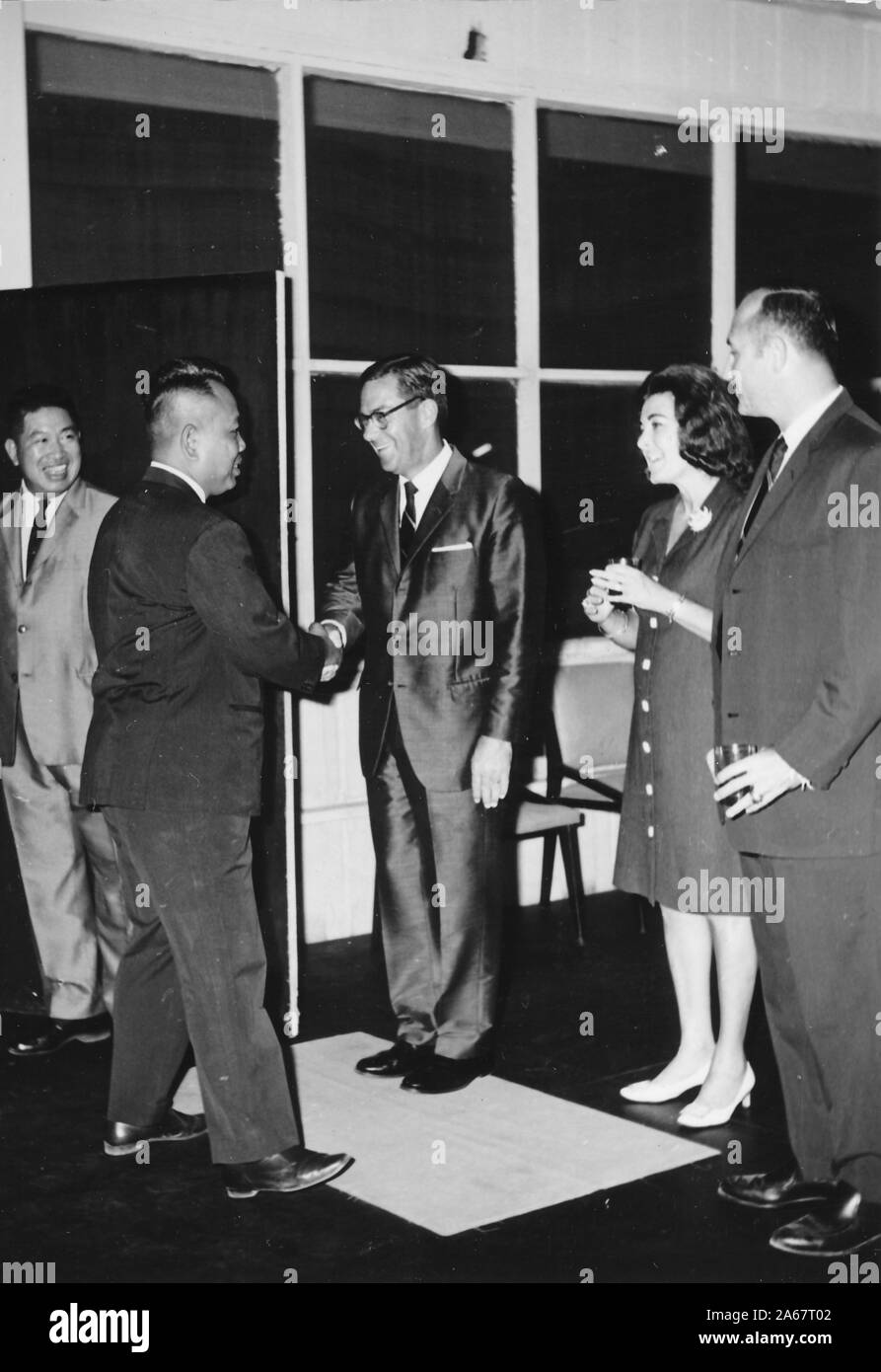 Full-length shot of formally dressed men and women greeting each other ...