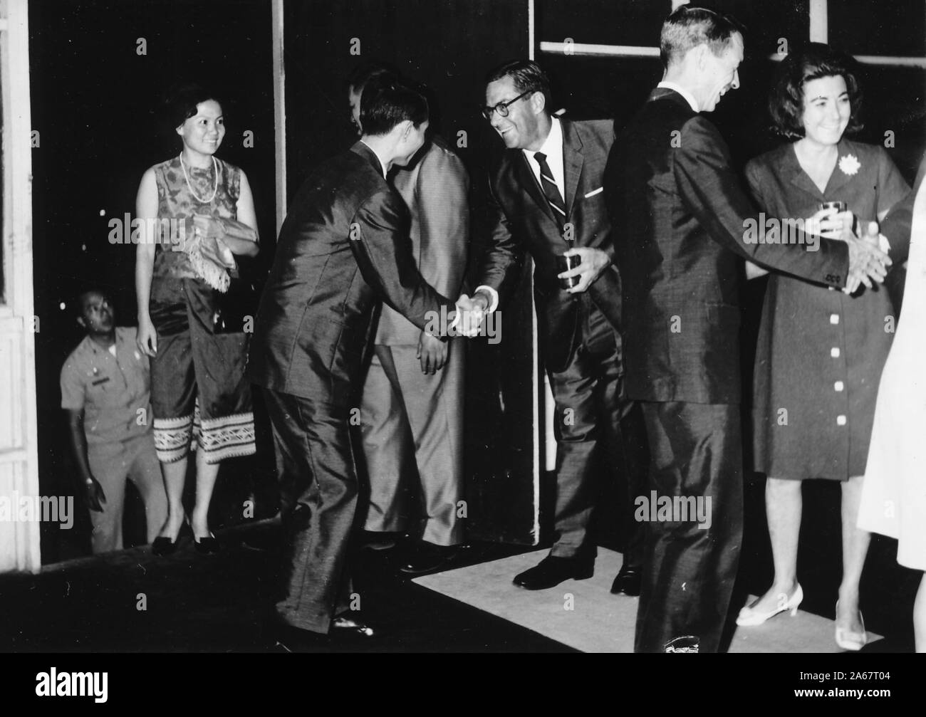 Full-length shot of formally dressed men and women greeting each other ...