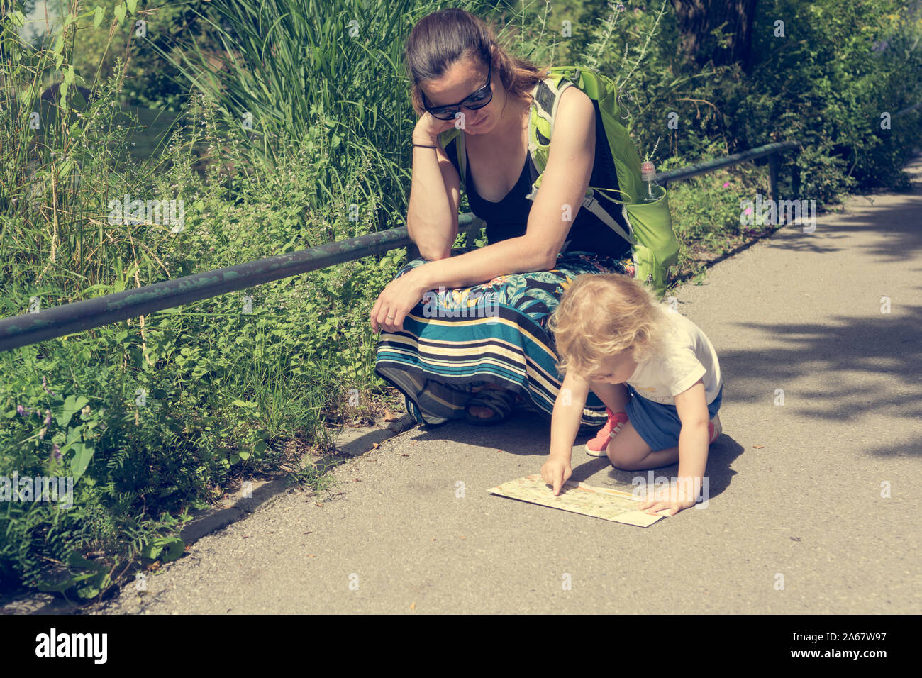 Mother and daughter looking at a map and planning which way to take ...
