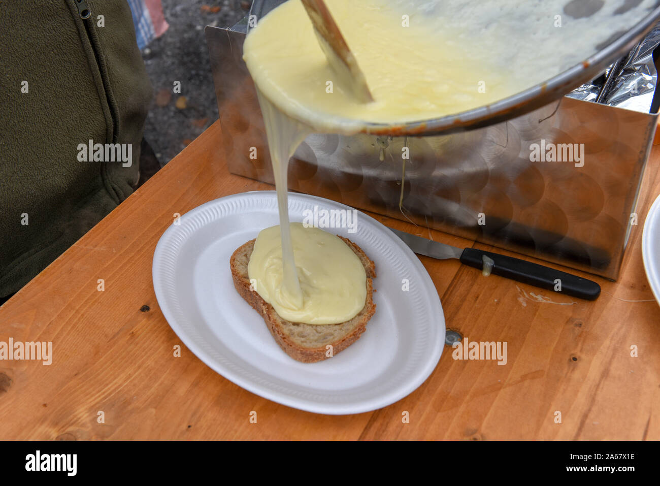 The preparation of traditional melted cheese on a bread on the Swiss ...