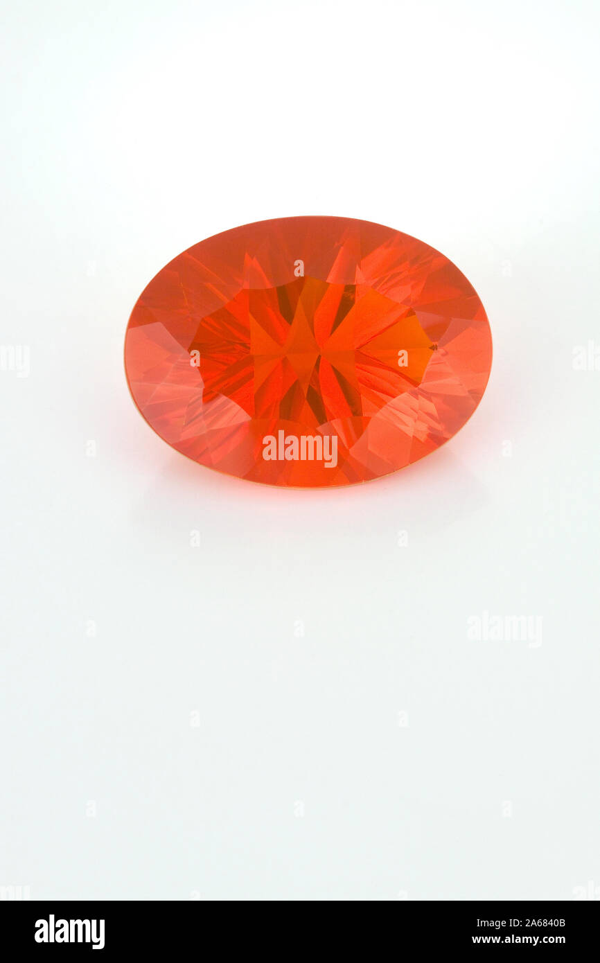 A large oval faceted mexican fire opal shown on a white background. The ...