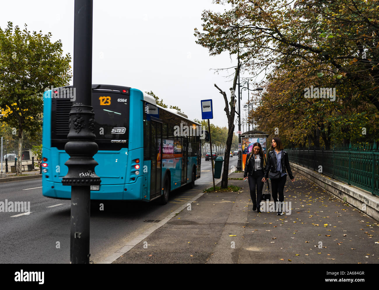 Girls walking on the sidewalk while the bus stops in the bus station in ...