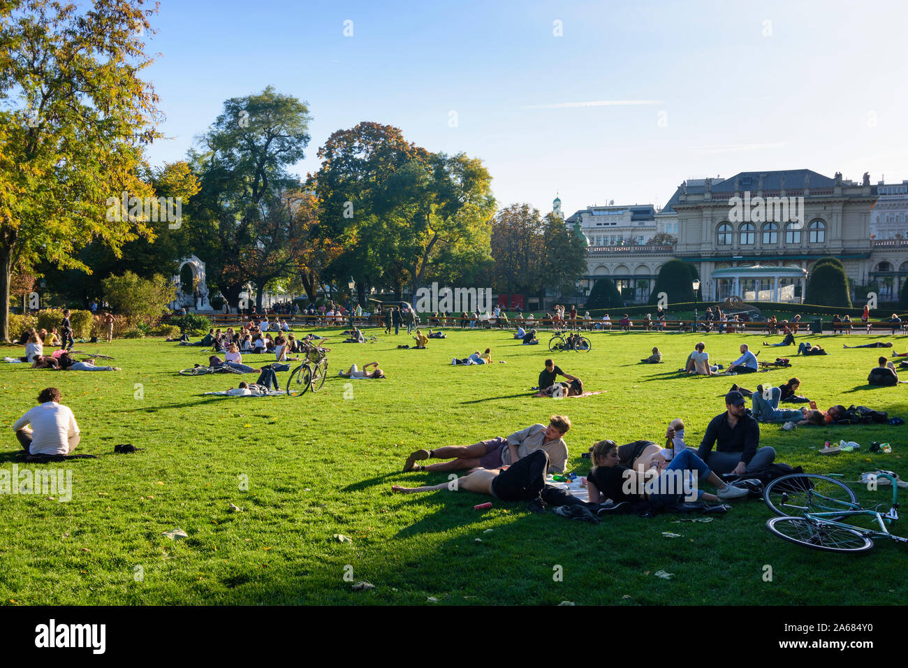 Wien, Vienna: park Stadtpark, meadow, people sunbathing, talking, house Kursalon Hübner in ...