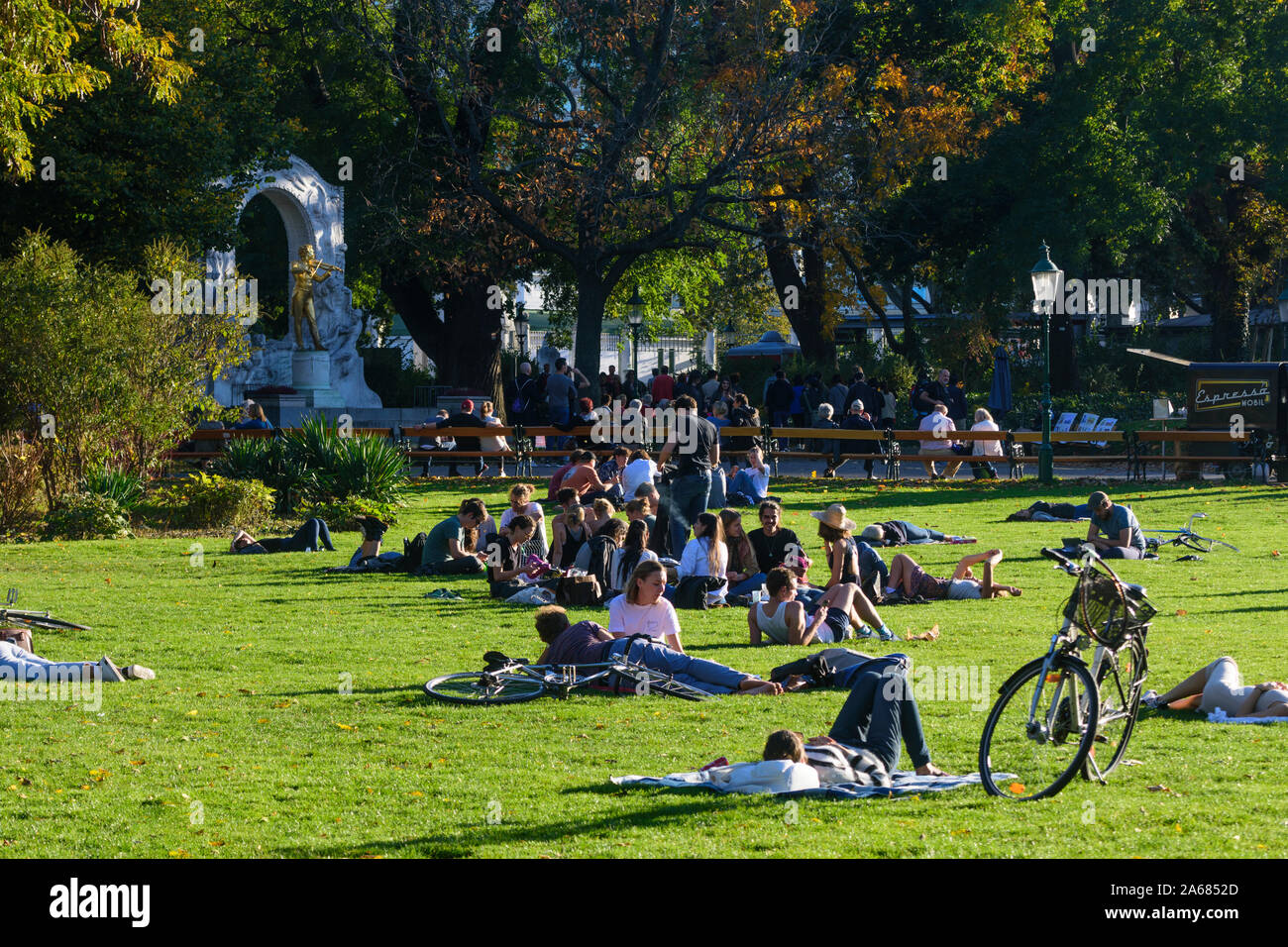 Wien, Vienna: park Stadtpark, meadow, people sunbathing, resting, talking, Johann Strauß ...