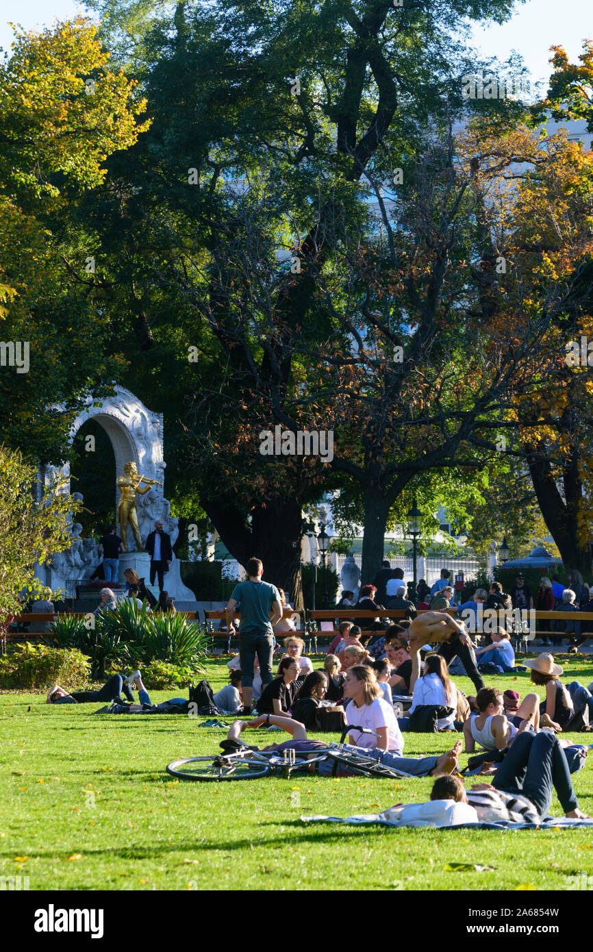 Wien, Vienna: park Stadtpark, meadow, people sunbathing, resting, talking, Johann Strauß ...