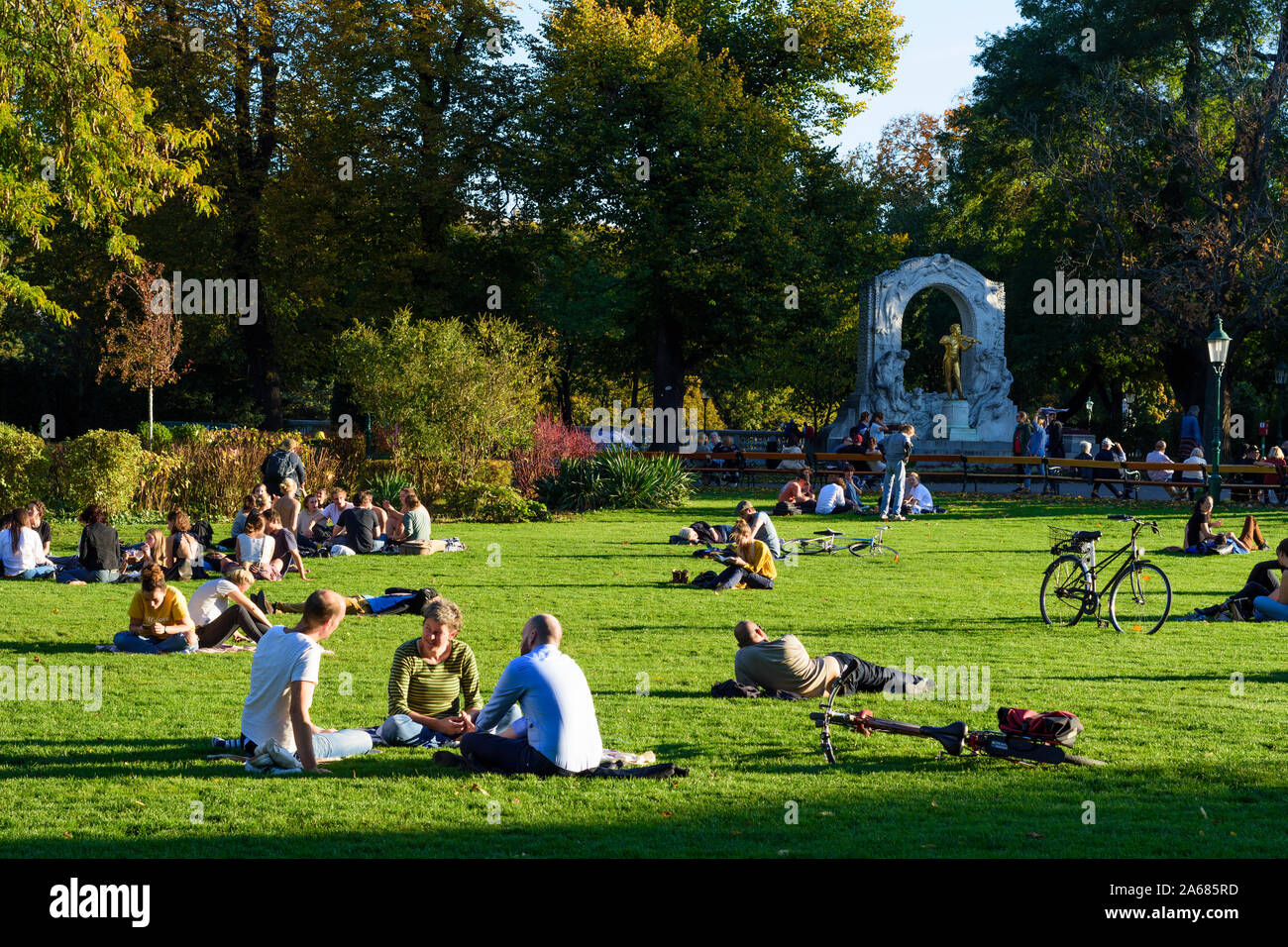 Wien, Vienna: park Stadtpark, meadow, people sunbathing, resting, talking, Johann Strauß ...