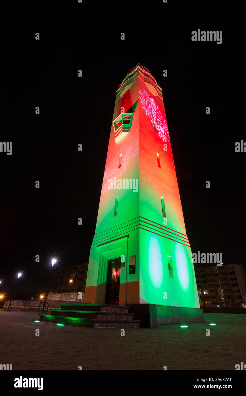 square shaped Lighthouse on Holland seashore at night lit with green ...