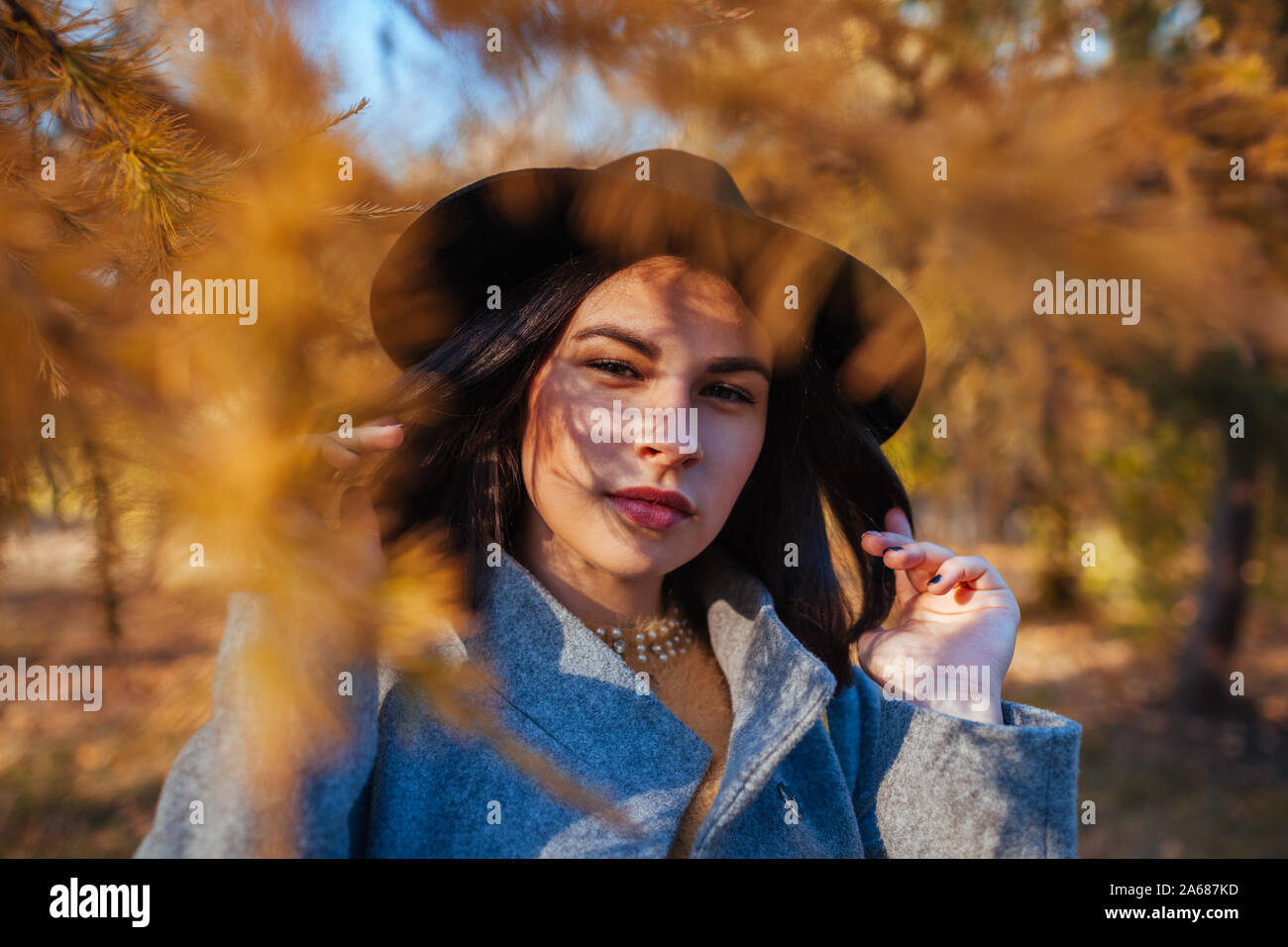Autumn fashion. Portrait of young woman with shadow on face wearing ...