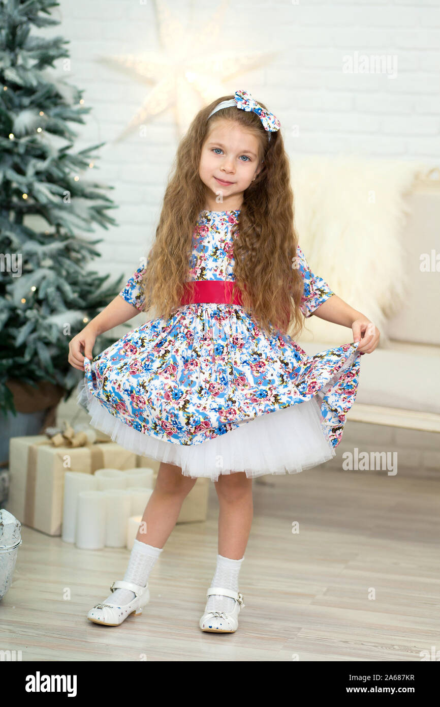 Cute little girl in a beautiful pose near the Christmas tree Stock ...