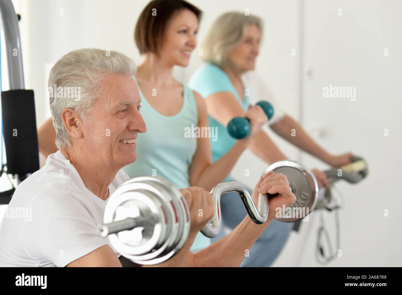 Portrait of active smiling people exercising in gym Stock Photo - Alamy