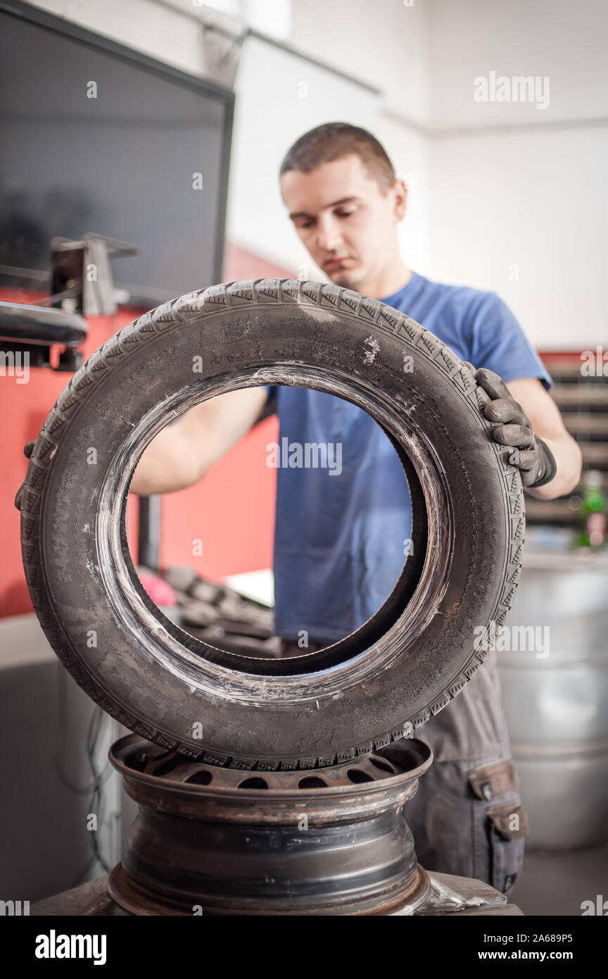 Car master mechanic vulcanizer replaces and changes old with new tires ...