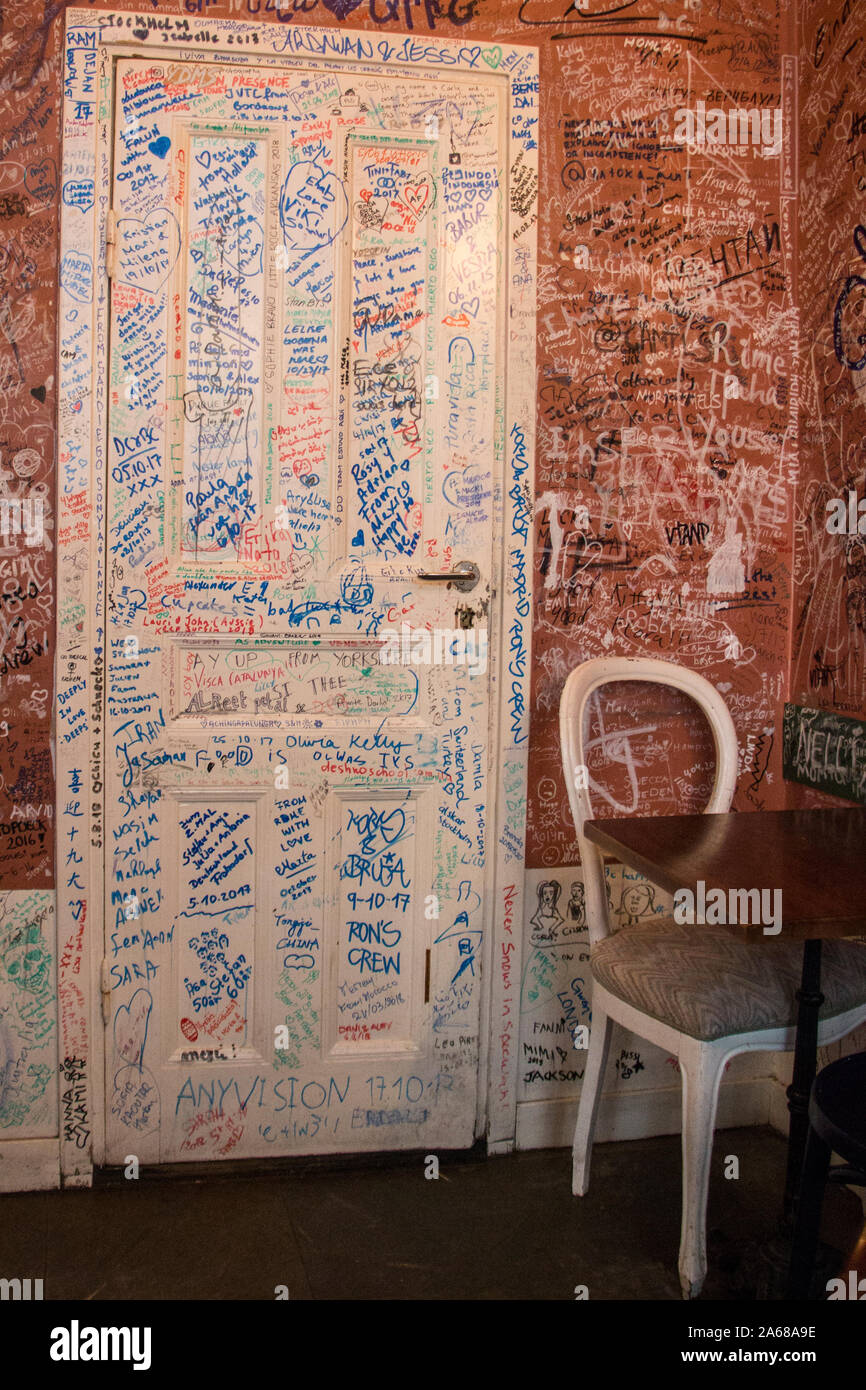Café diner walls painted in ocre and white being tagged with hundreds ...