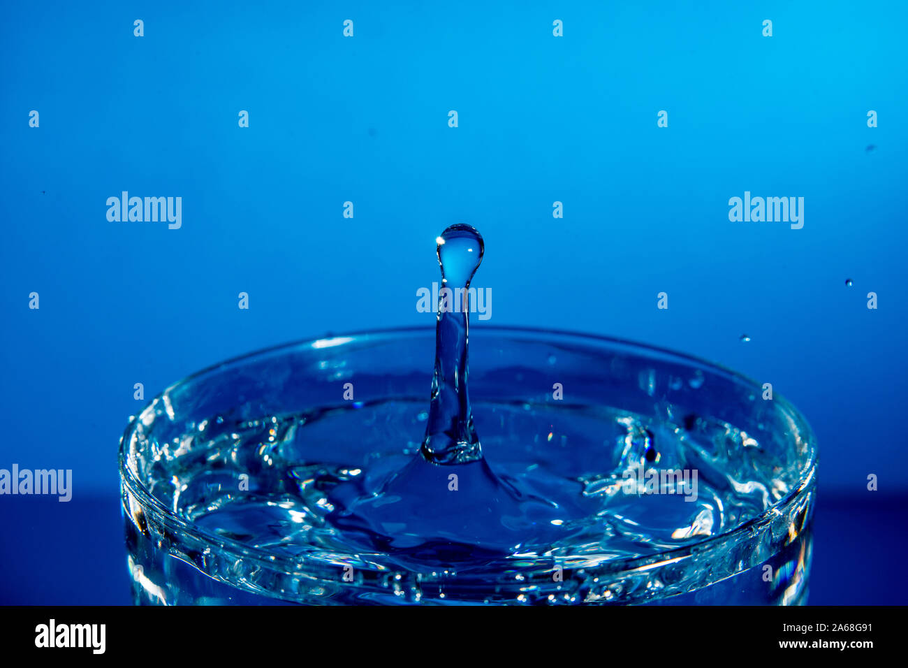 Drop of water falling into a glass, hitting water surface.Selected ...