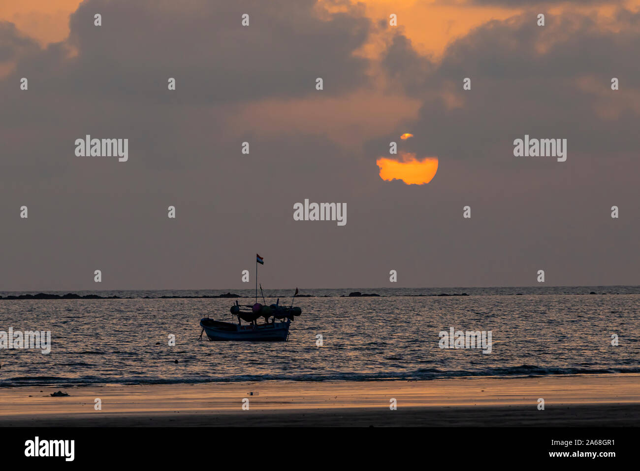 Fishing boat on the water and dramatic clouds at sunrise at bassien ...