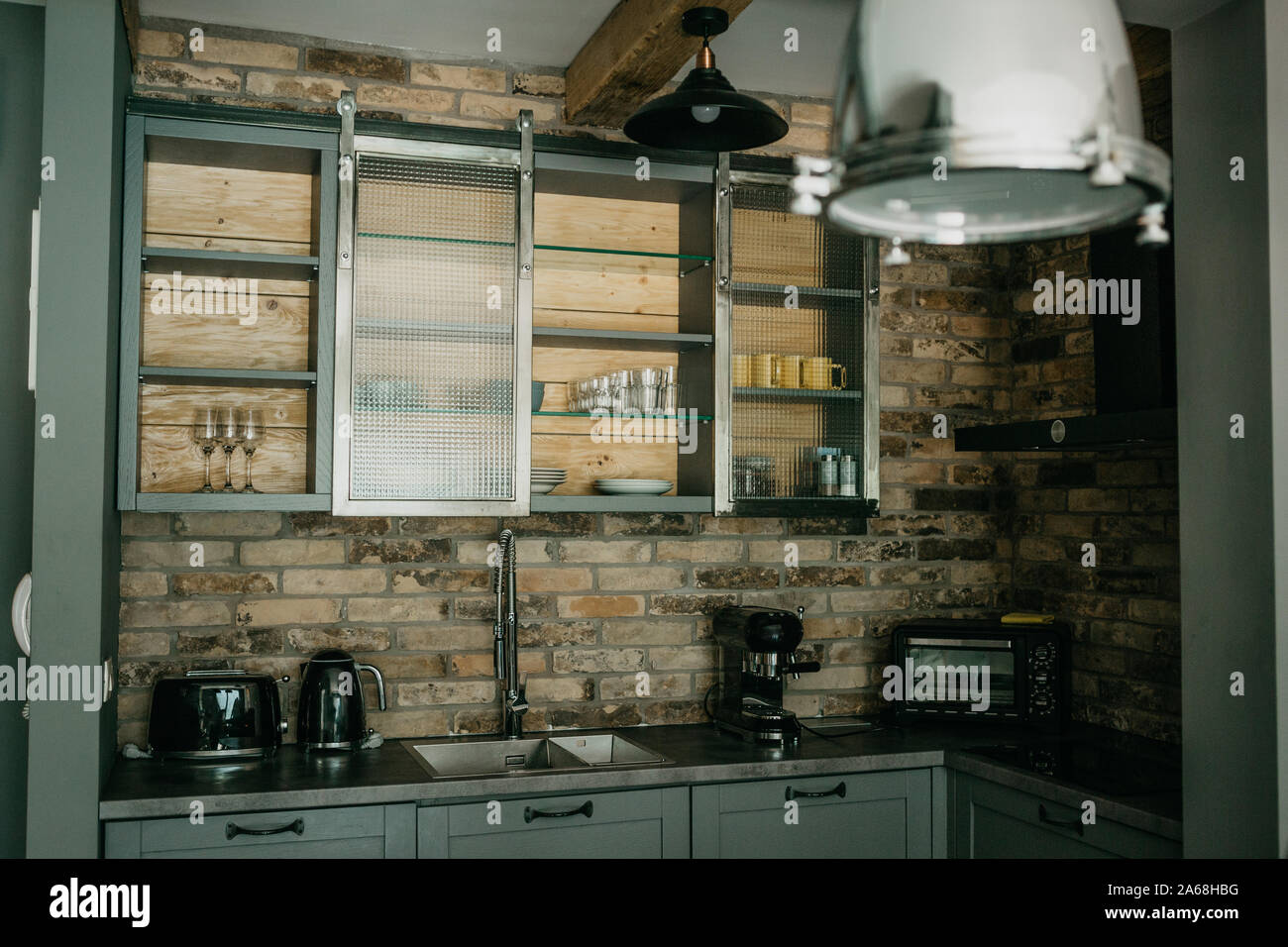 Kitchen with a brick wall with a faucet, kettle, toaster, coffee maker ...