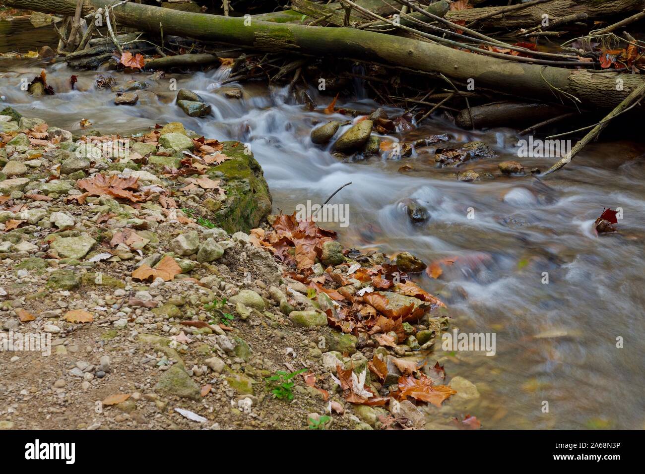 Rippling stream flowing with long exposure softened water over rocks ...