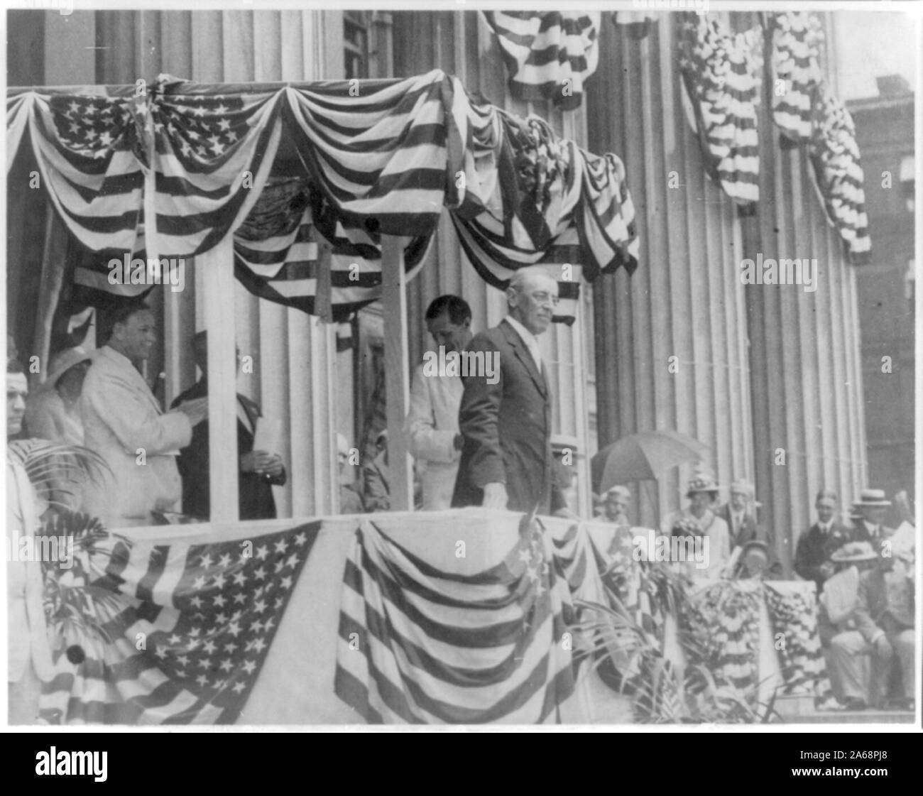 Woodrow Wilson, 1856-1924, half-length, facing right, standing on flag ...
