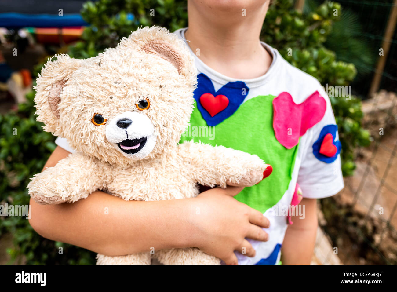 Sad abandoned child hugging his scared teddy bear before the loneliness ...