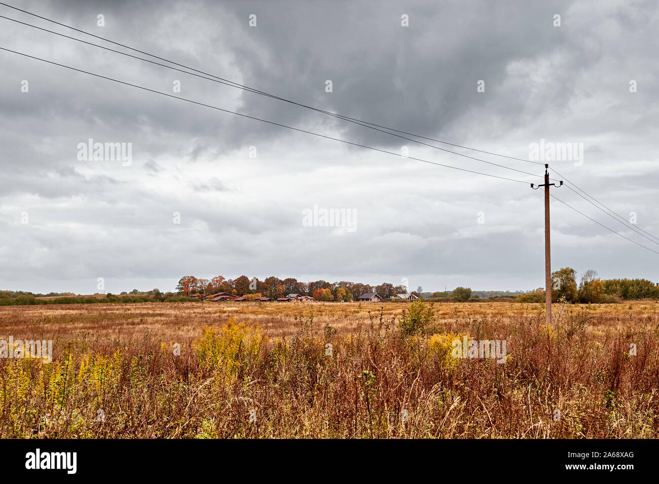 Autumn panoramic landscape with wooden houses, field and dramatic ...