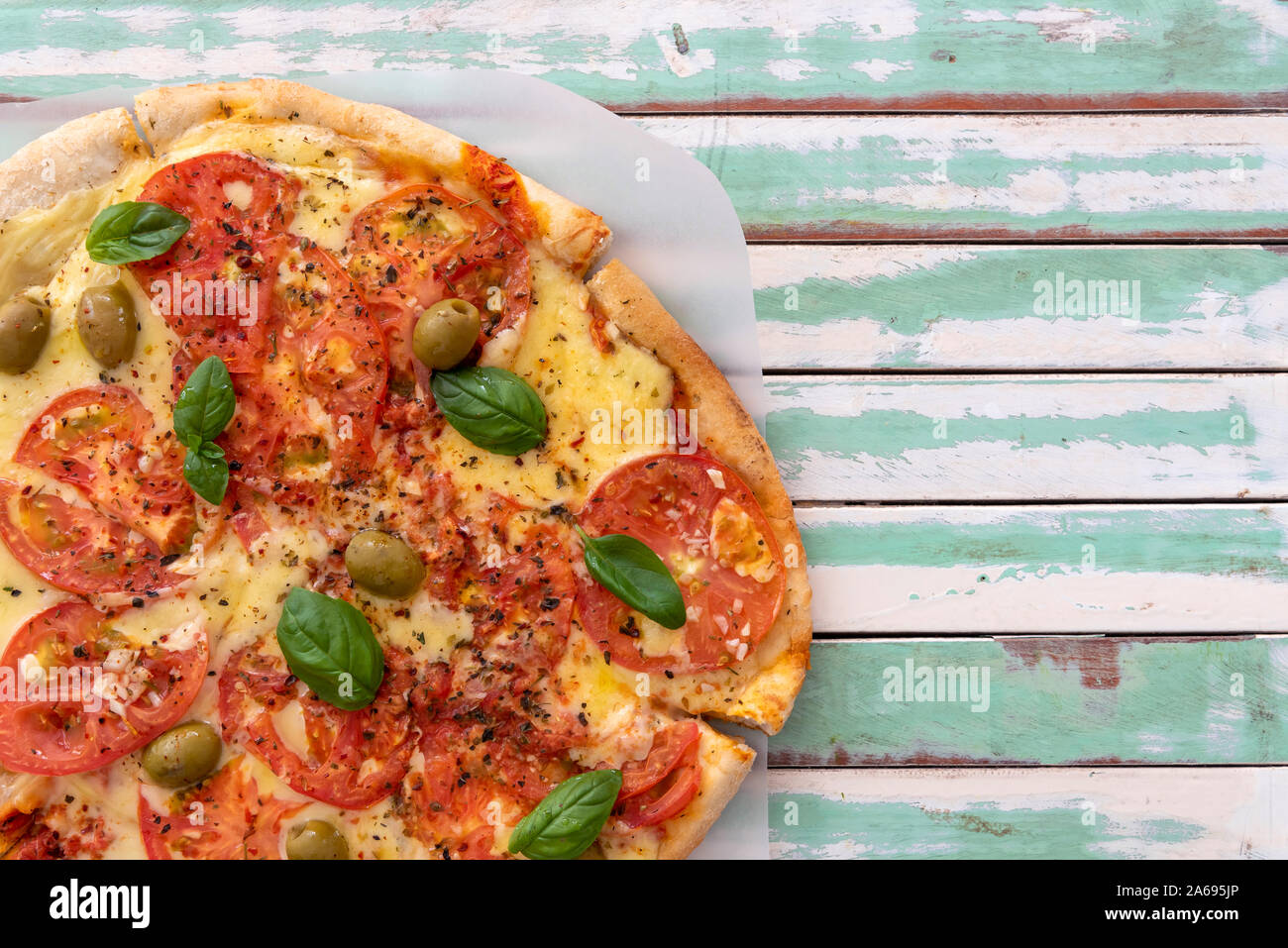 Freshly made wood fired pizza viewed from above on rustic turquoise ...