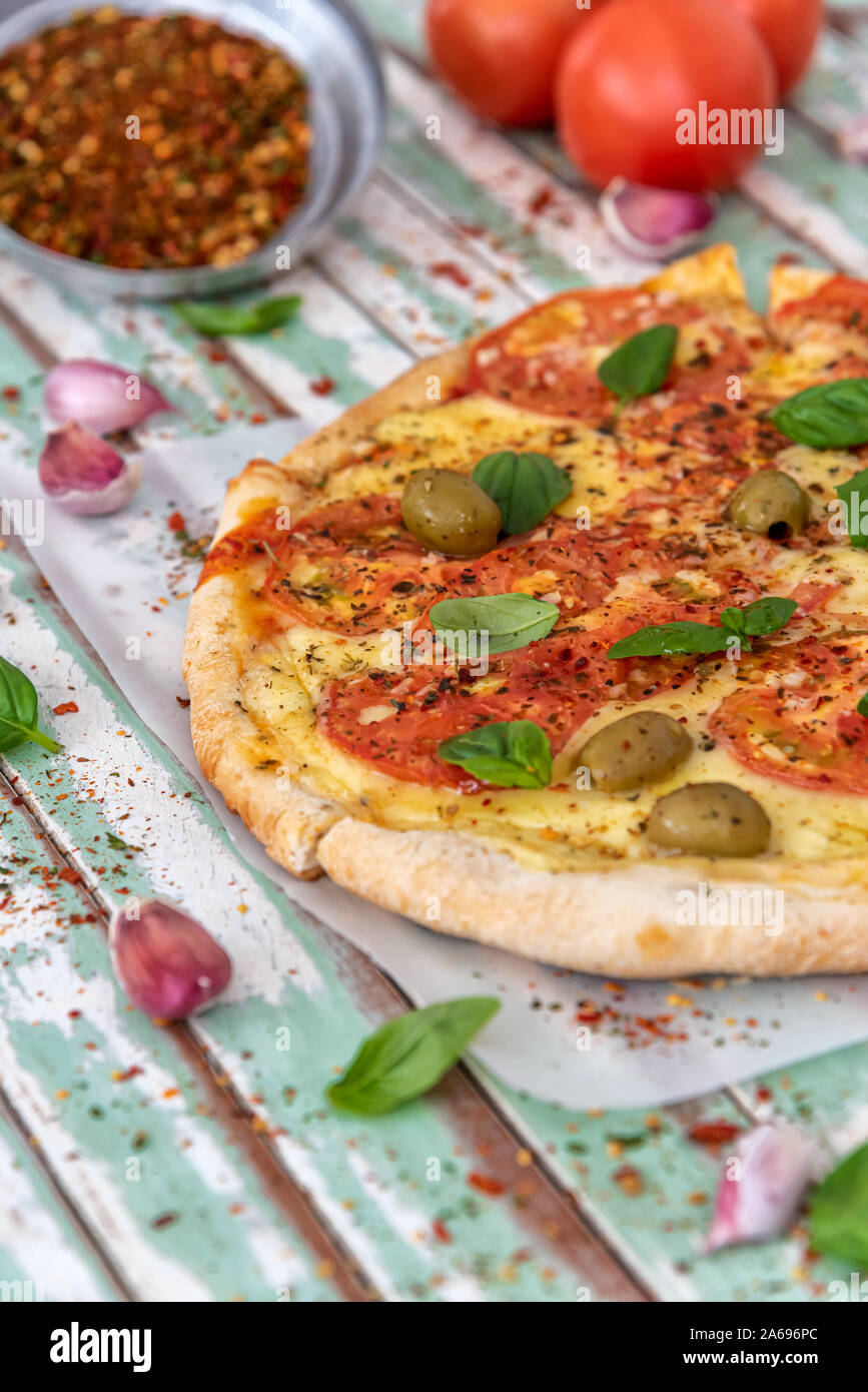 Freshly made wood fired pizza viewed from above on rustic turquoise ...