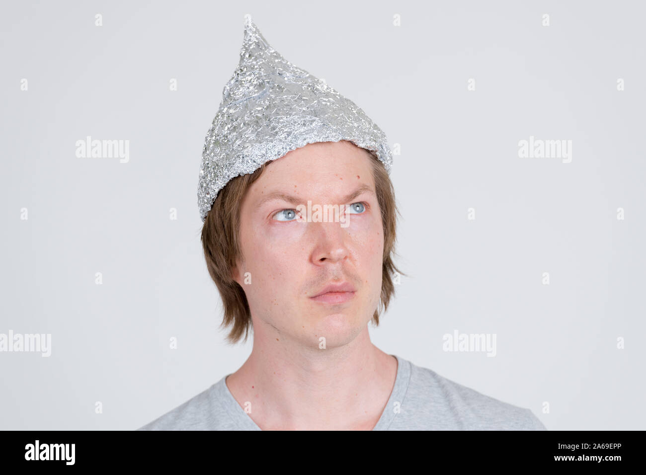 Face of young man with tinfoil hat thinking as conspiracy theory ...