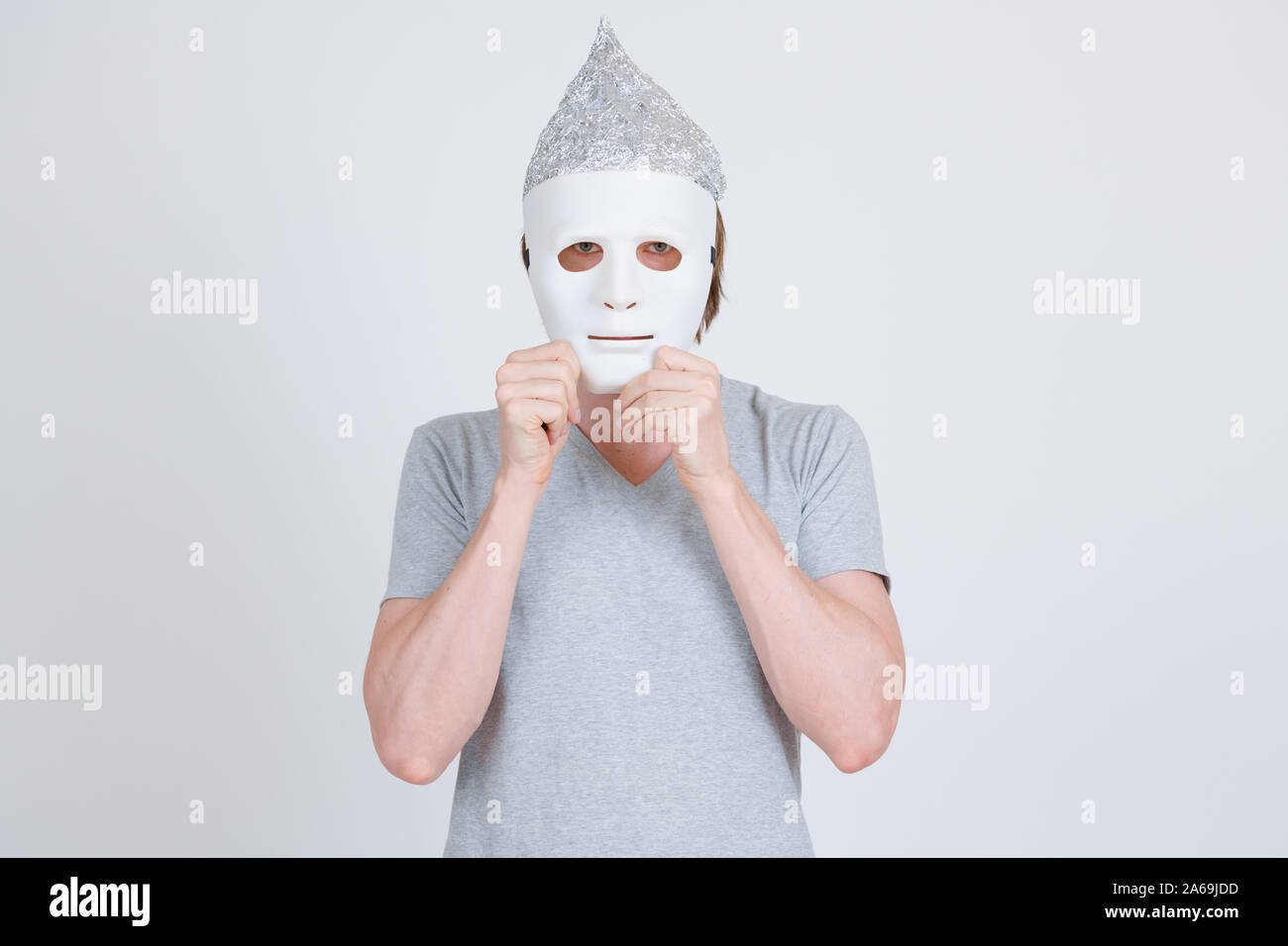 Young man with tinfoil hat as conspiracy theory concept wearing white ...