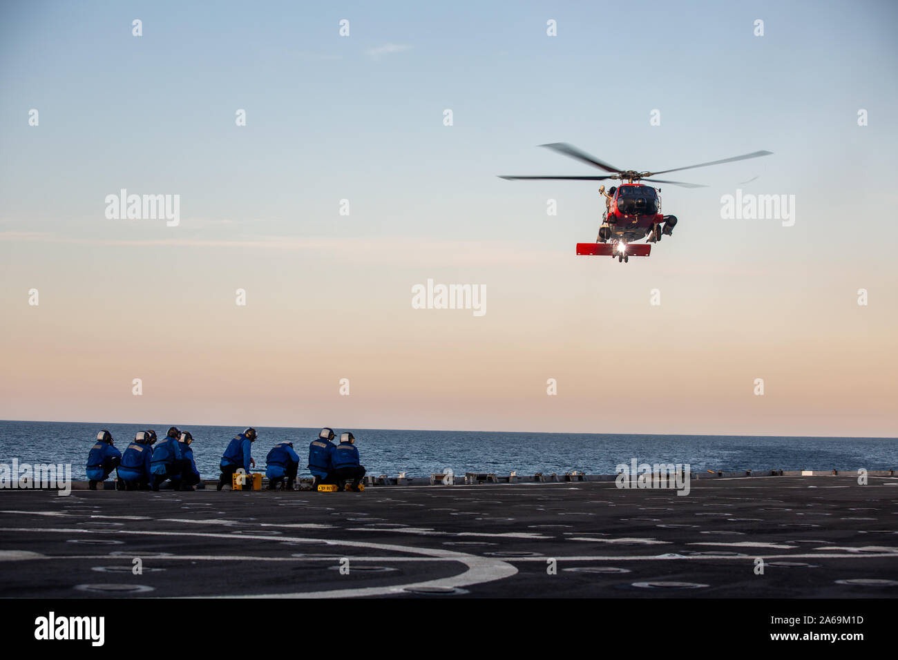 U.S. Sailors assigned to the USS Comstock (LSD-45), await the landing ...