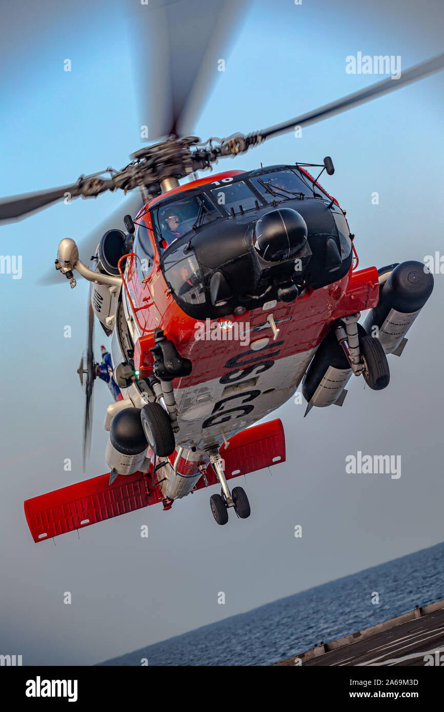 U.S. Coast Guardsmen pilot a UH-60 Blackhawk helicopter while ...