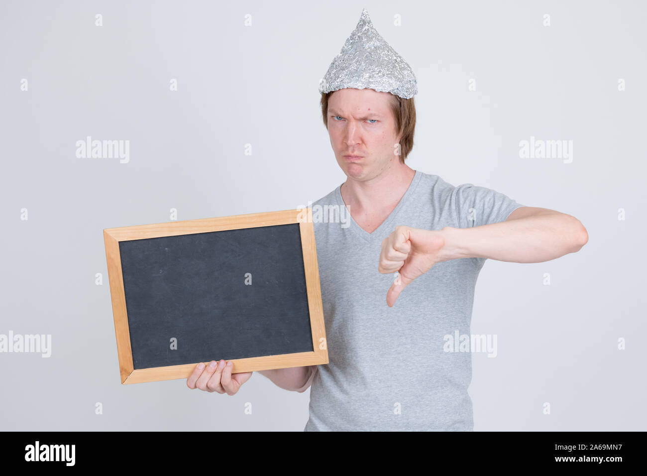 Angry young man with tin foil hat holding blackboard and giving thumbs ...