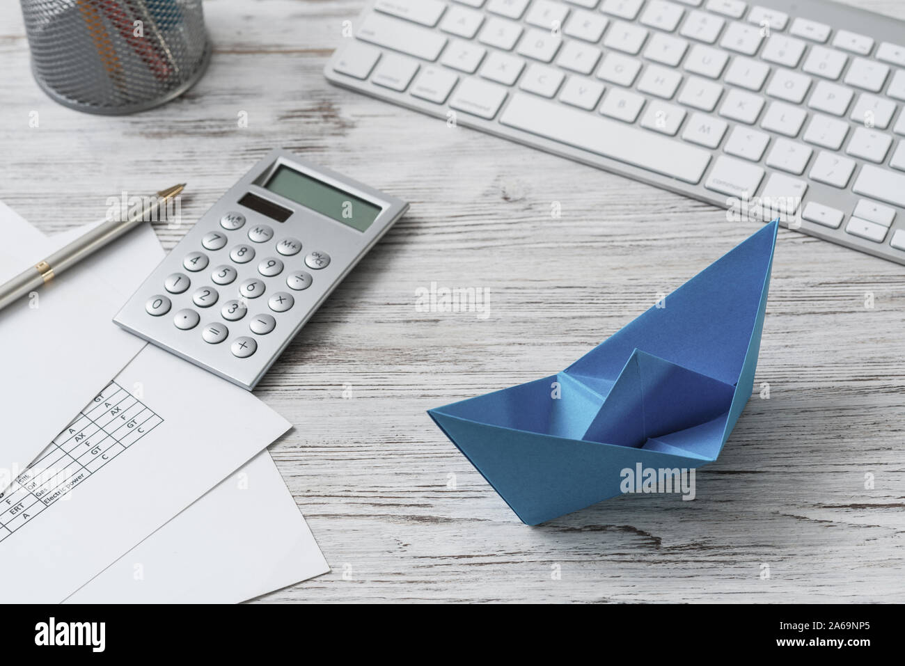 Modern office workspace with blue paper ship. Corporate strategy and ...