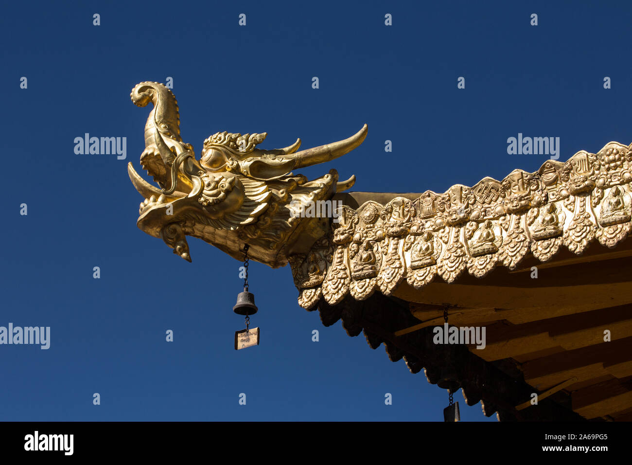 Gilded statues of Garuda and a dragon on the roof of the Jokhang Temple ...
