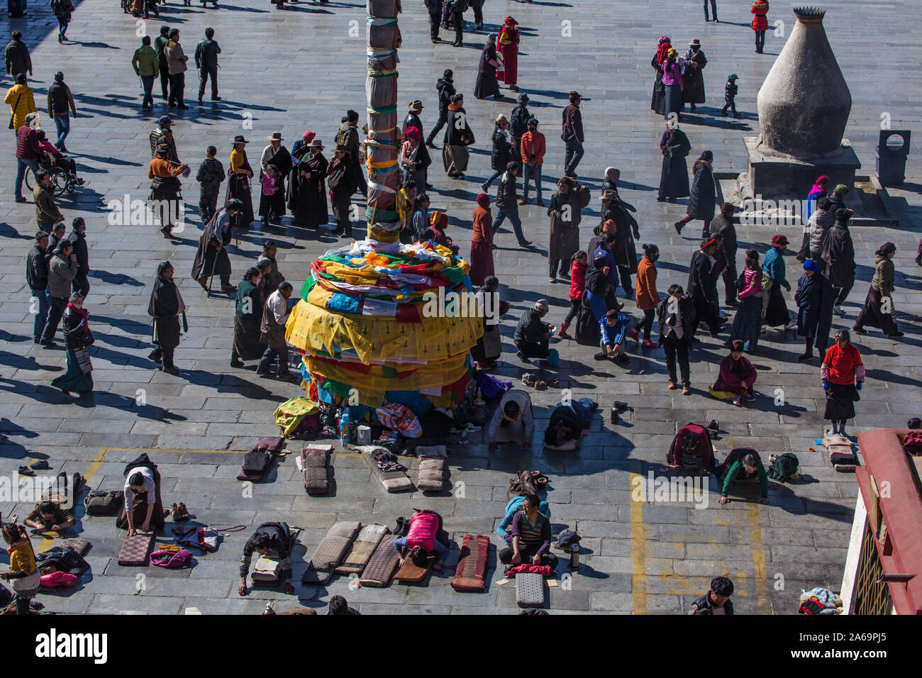 Tibetan pilgrims circumambulate around and prostrate themselves in ...