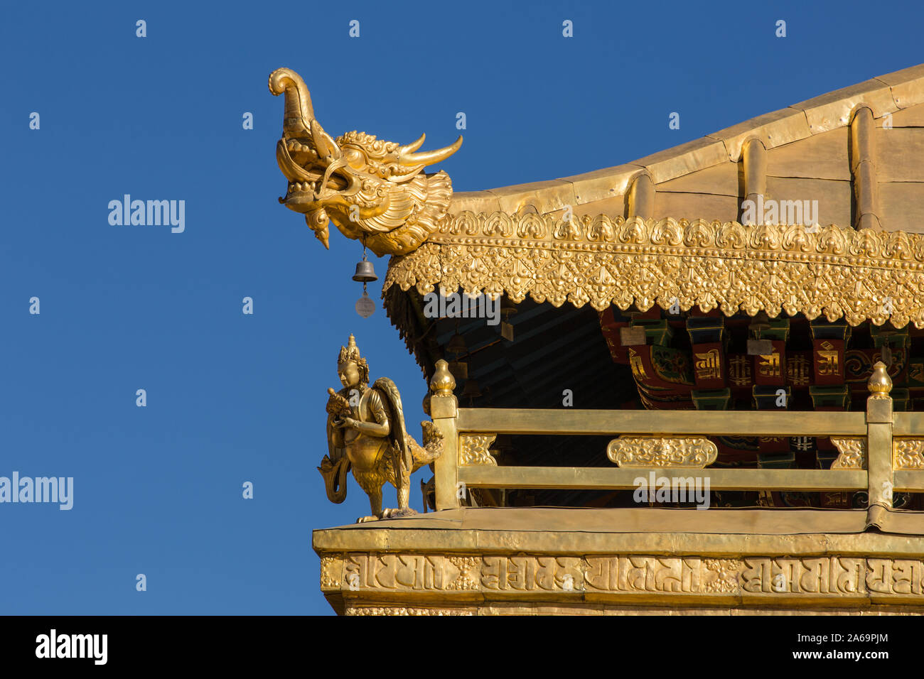 Gilded statues of Garuda and a dragon on the roof of the Jokhang Temple ...