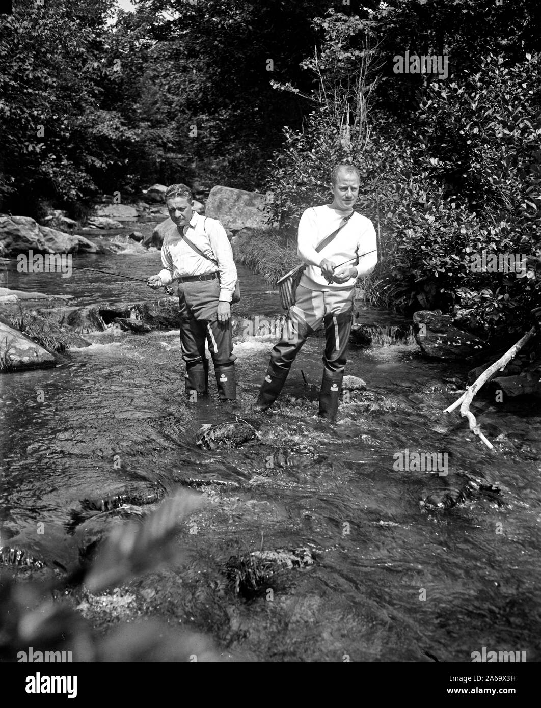 Two men fishing in a river ca. 1932 Stock Photo - Alamy