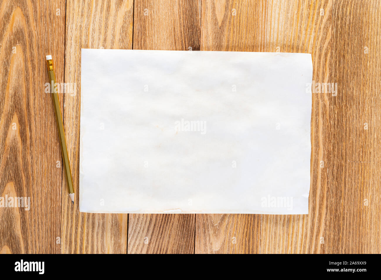 Sheet of paper lying on wooden table. Top view of rectangular blank ...
