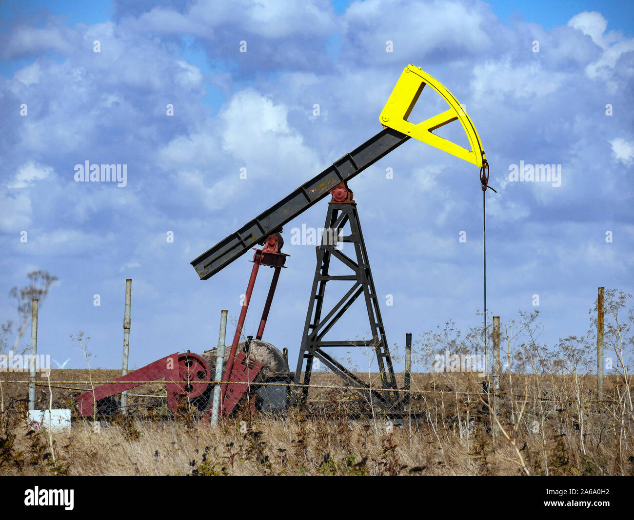 An old oil pump in the field. Abandoned and rusty. Technology for the ...