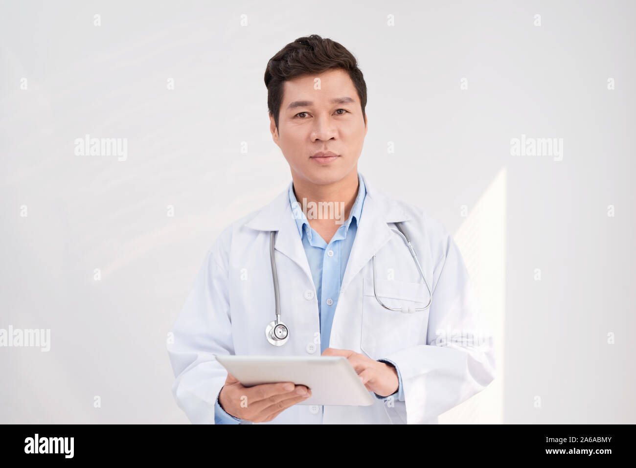 Smiling asian medical doctor standing man isolated hi-res stock ...