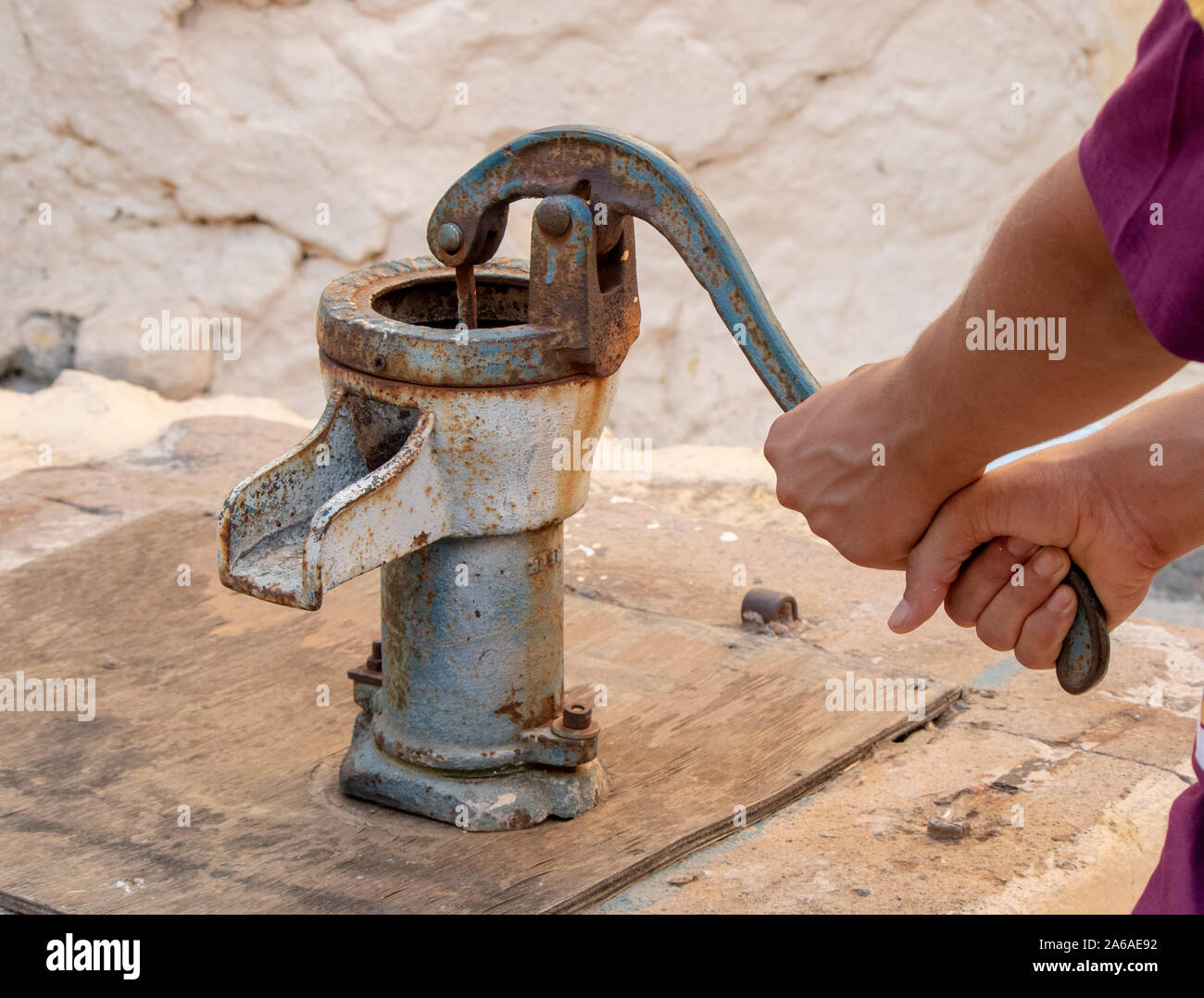 Old historic water pump. Hand pressing the handle on the pump Stock ...