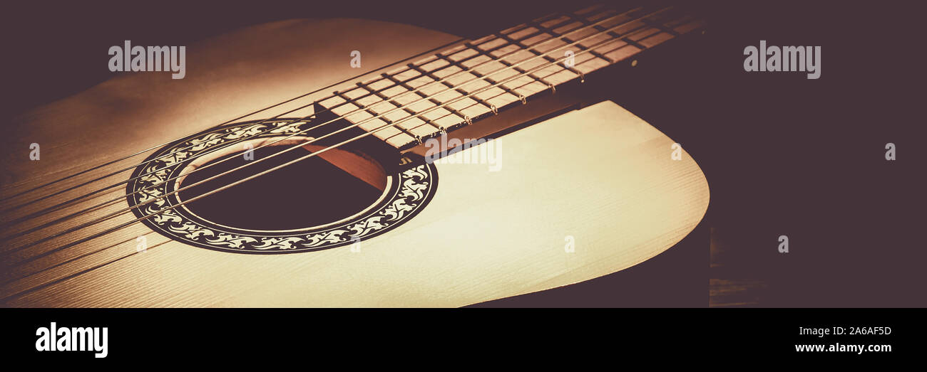 Acoustic guitar lying on a wooden table lit by a beam of light Stock ...