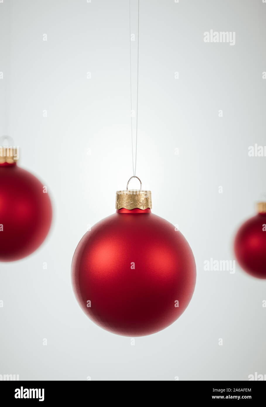 Three red Christmas baubles hanging in front of white background for ...