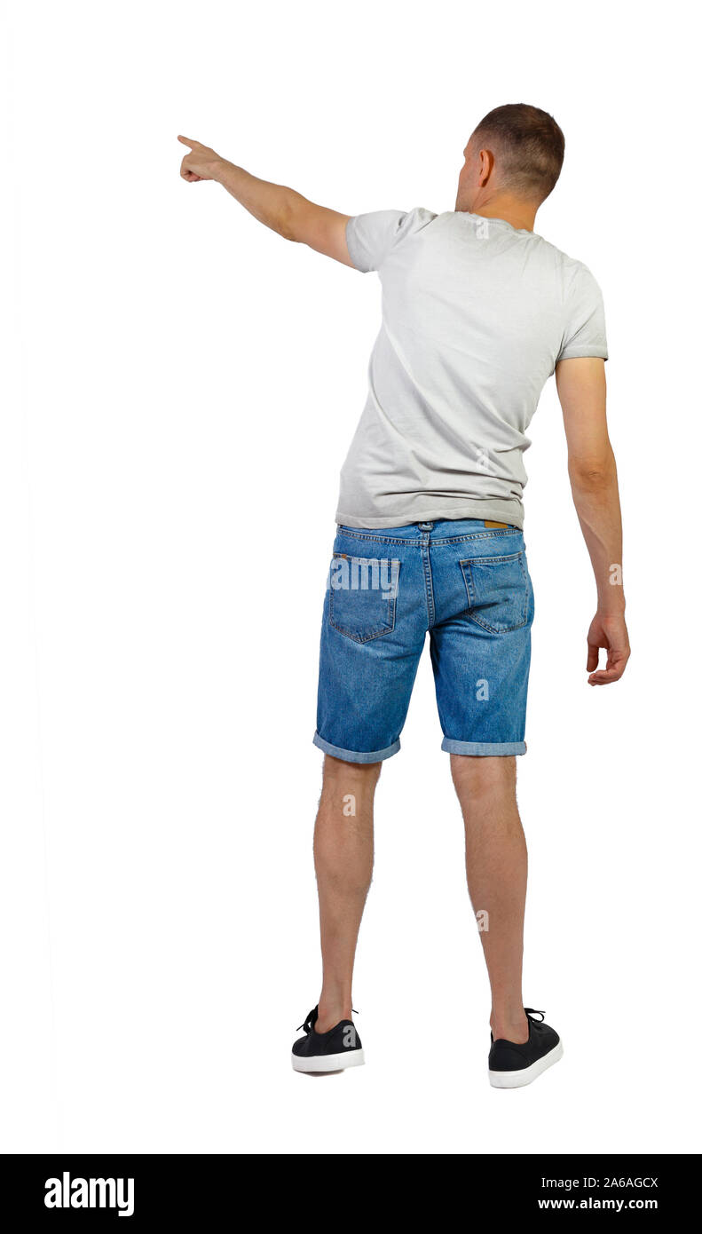Back view of going handsome man in shorts pointing. walking young guy ...