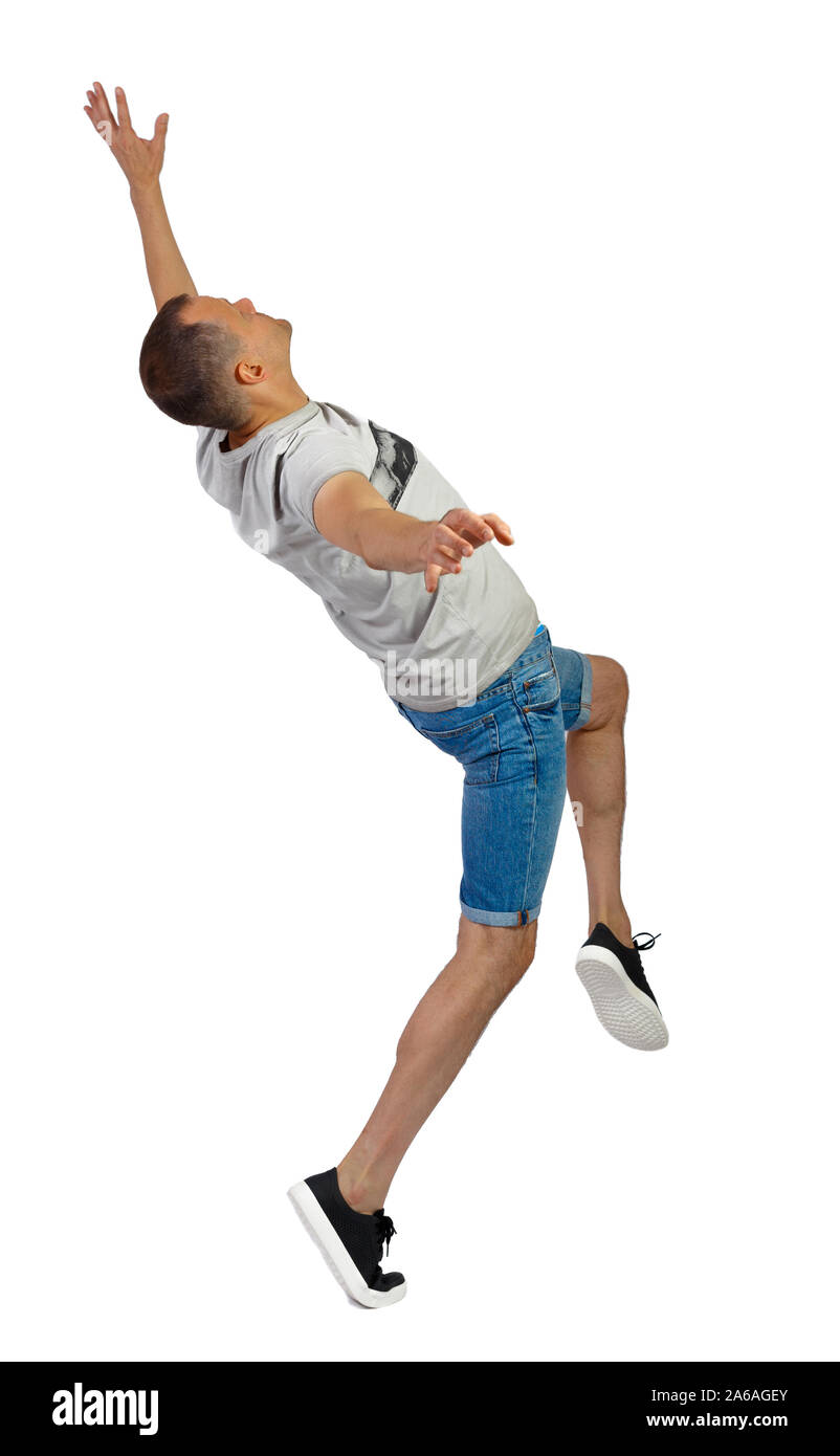 Side view of a man dancing in shorts. The guy is balancing. Rear view ...