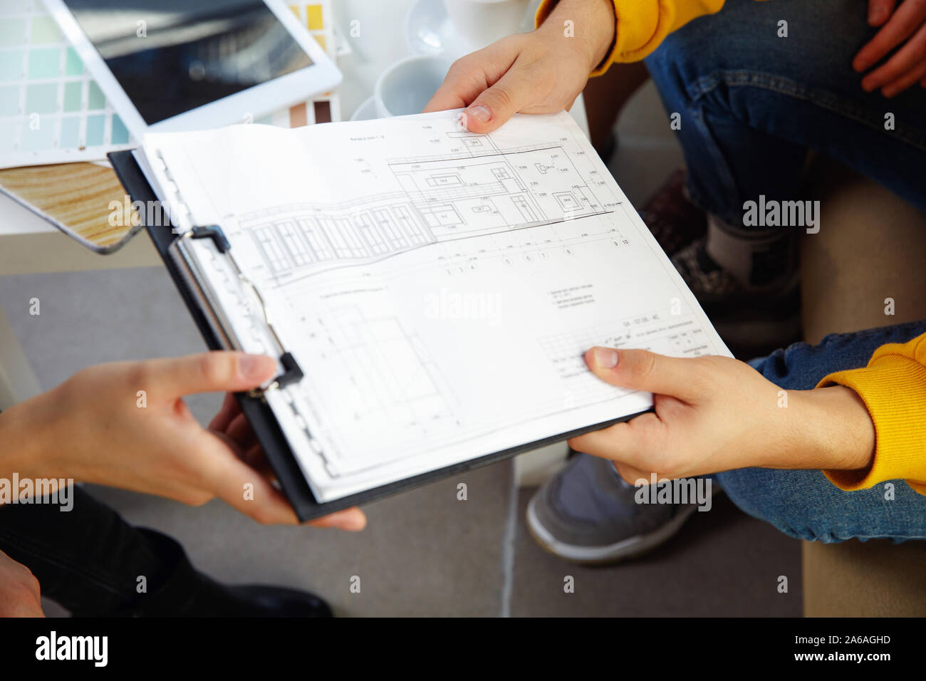 Interior designer working with young couple. Lovely family and ...